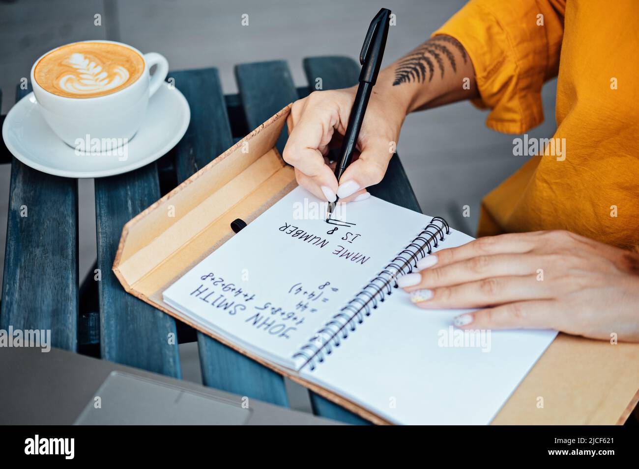 Woman numerologist working with numbers in notepad and laptop ...