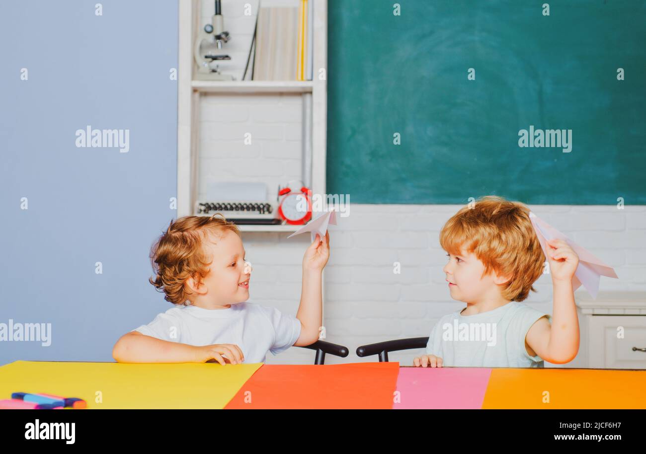Funny toddlers from elementary school hold paper plane laughing and ...