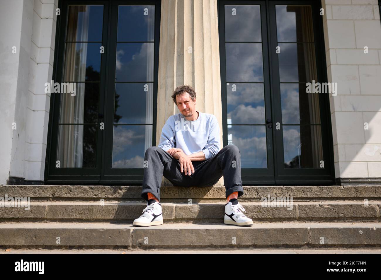 Hamburg, Germany. 11th June, 2022. Actor Hans Löw sits on the steps in ...