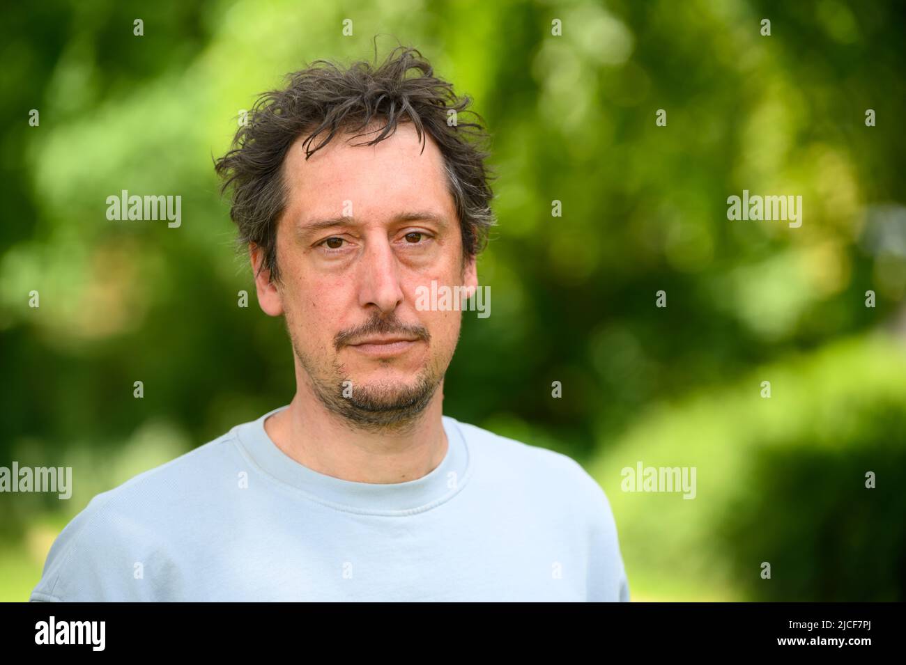 Hamburg, Germany. 11th June, 2022. Actor Hans Löw stands in Jenischpark ...