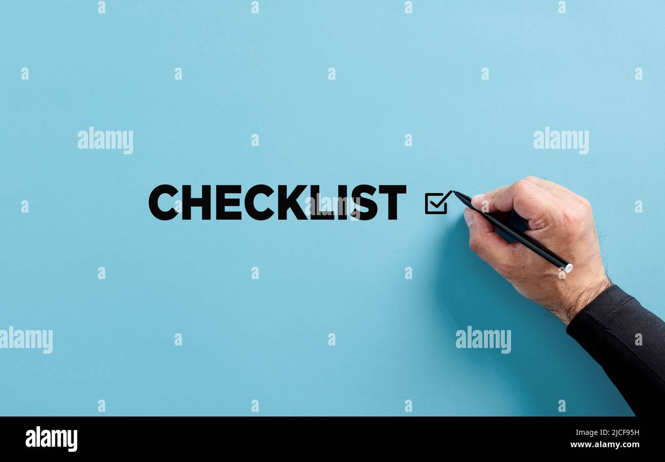 Male hand puts checkmark next to the word checklist. Checklist, to do ...