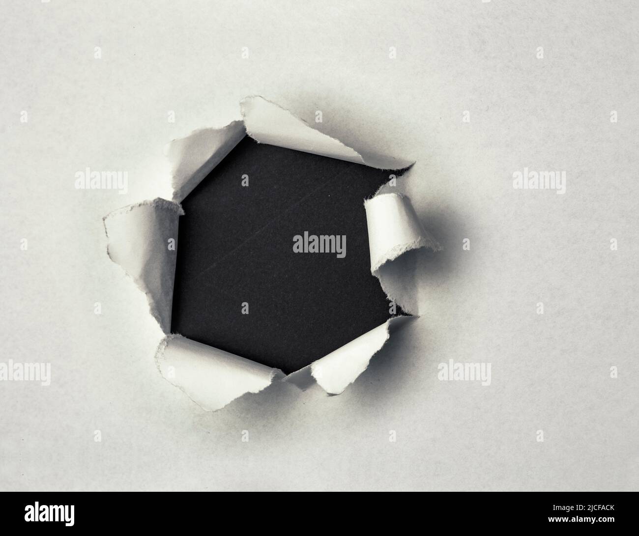 Hole in paper sheet with white background Stock Photo - Alamy