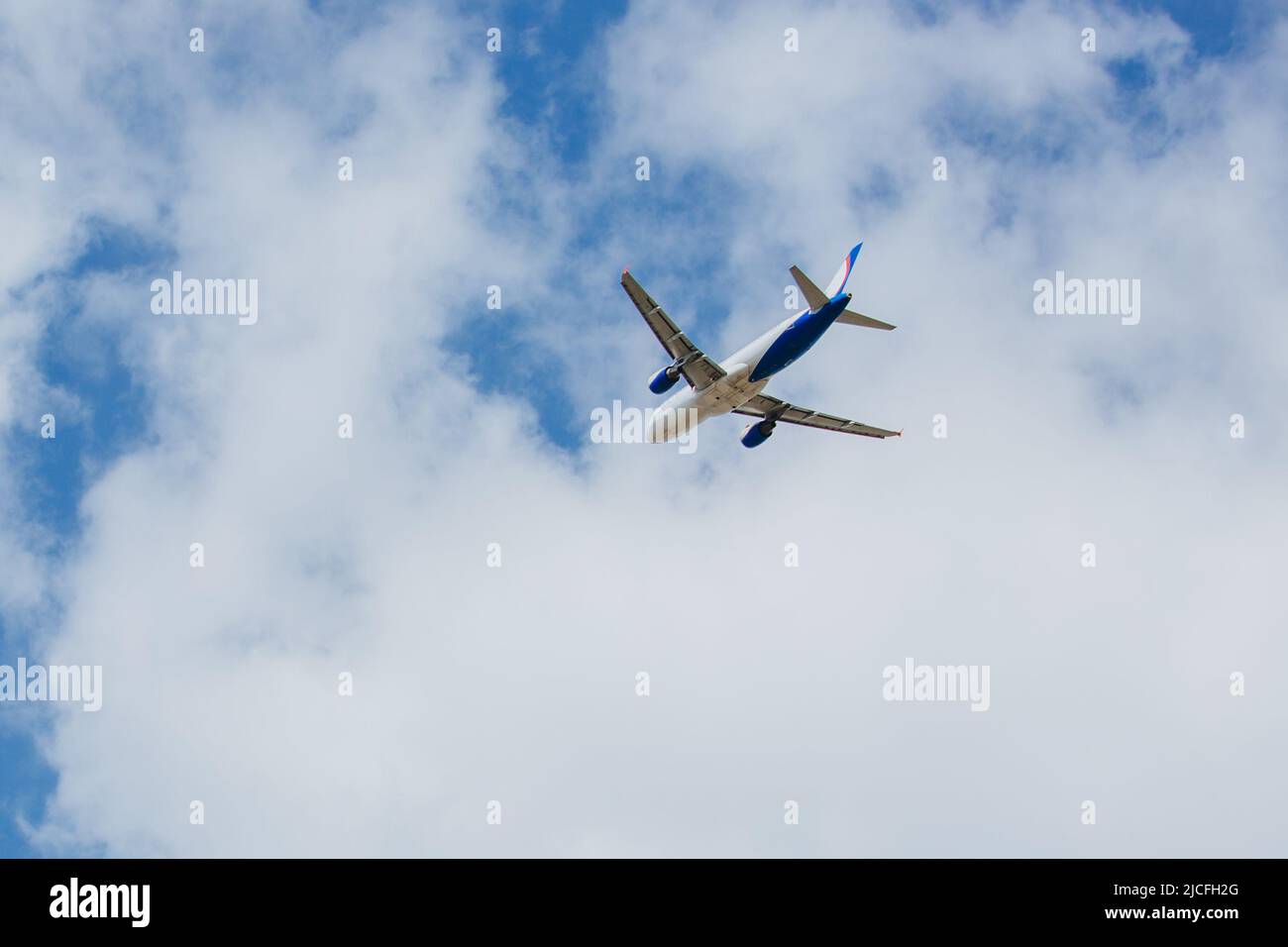 White- blue passenger airplane flying in the sky amazing clouds in the ...
