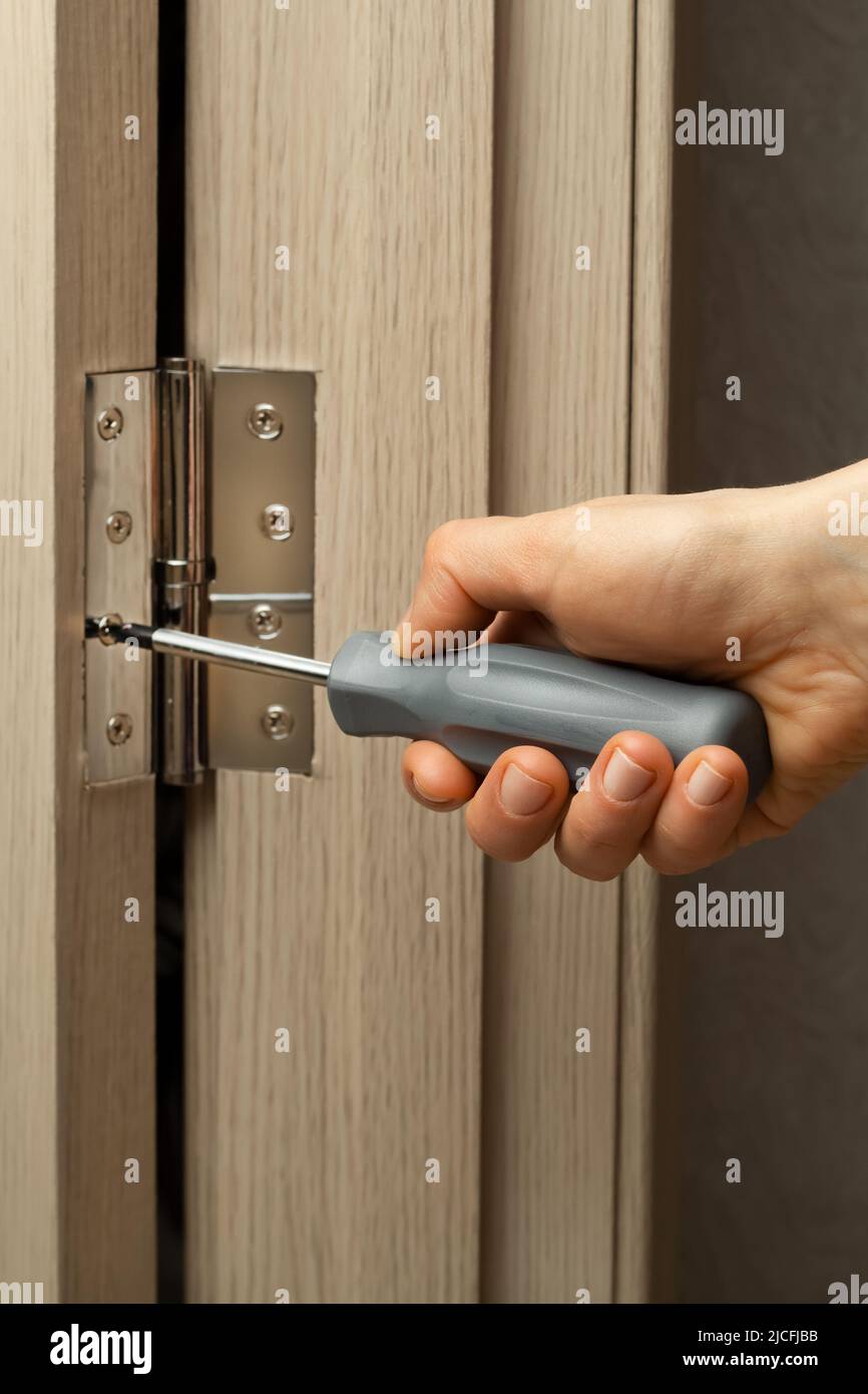 Carpenter installs a door hinge Stock Photo - Alamy
