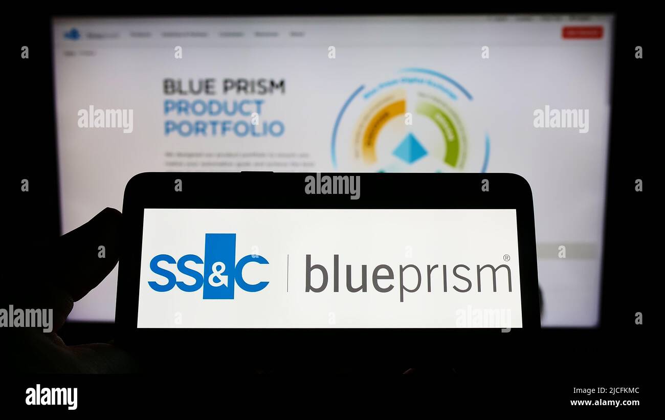 Person holding mobile phone with logo of British software company Blue ...