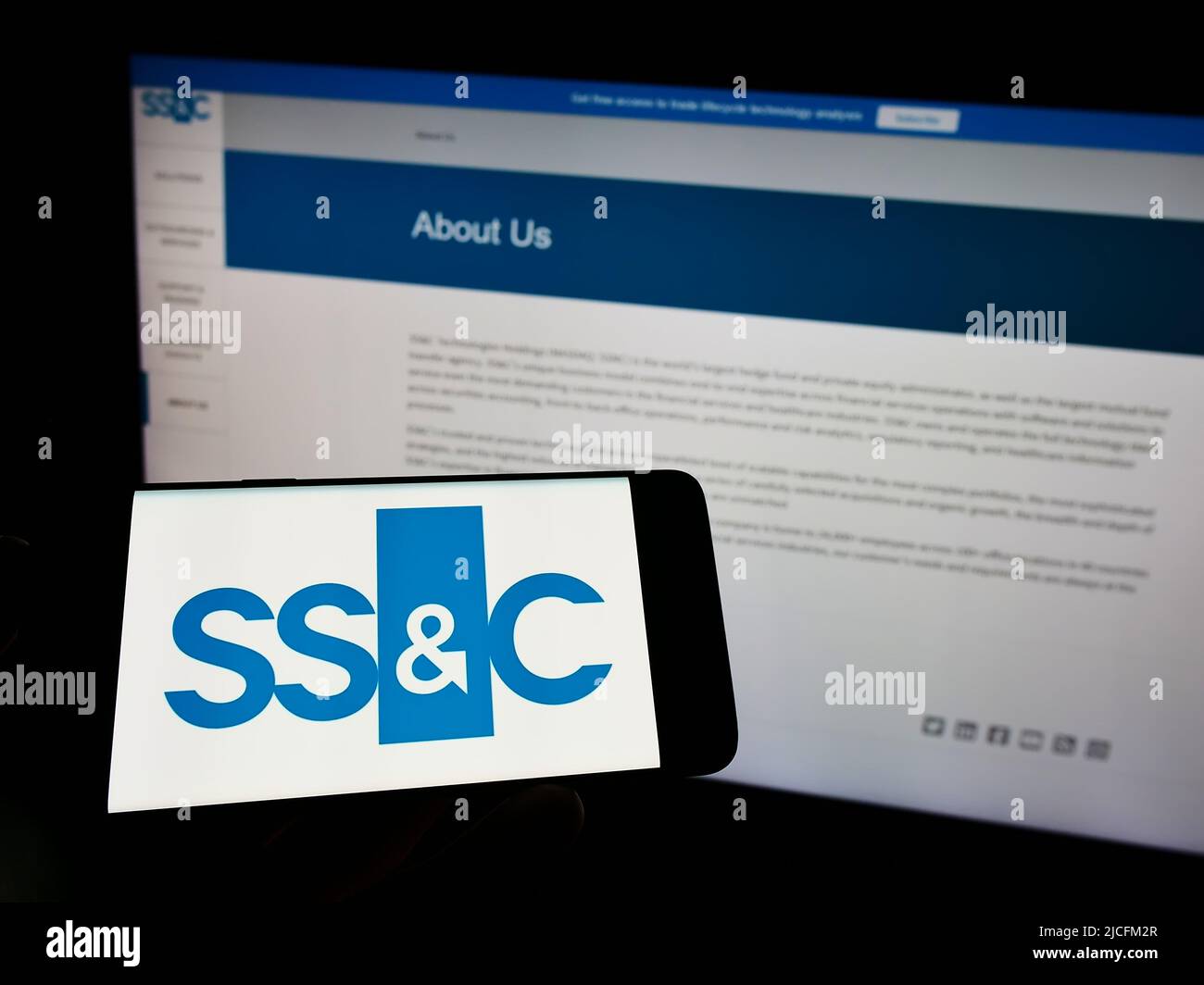 Person holding mobile phone with logo of American company SSC ...