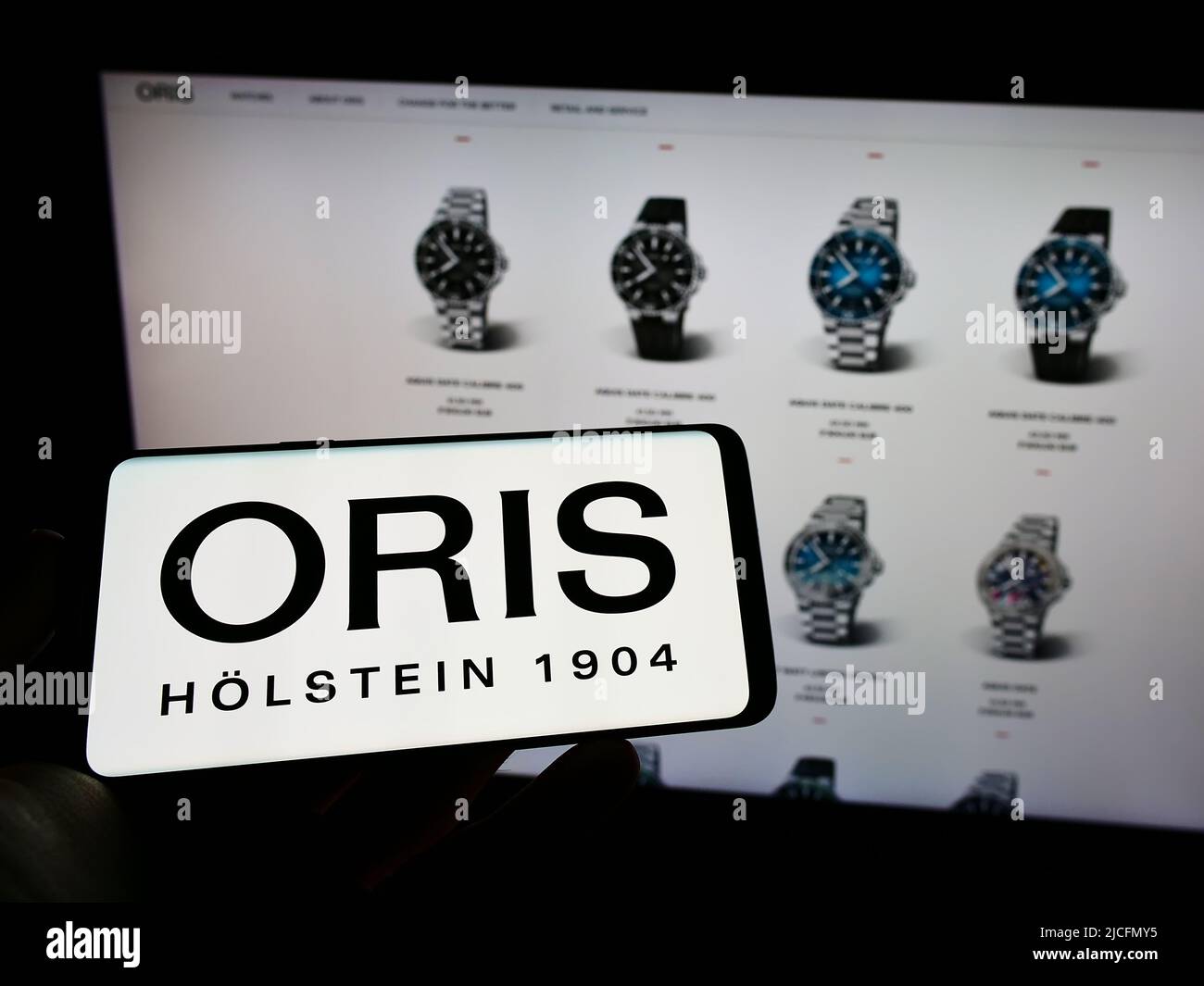 Person holding cellphone with logo of Swiss watch manufacturing company ...