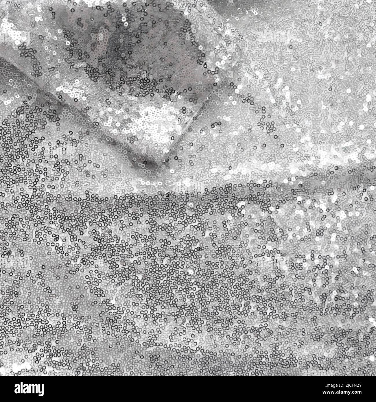 Silver white sequin fabric dress with one sleeve. Textile texture ...