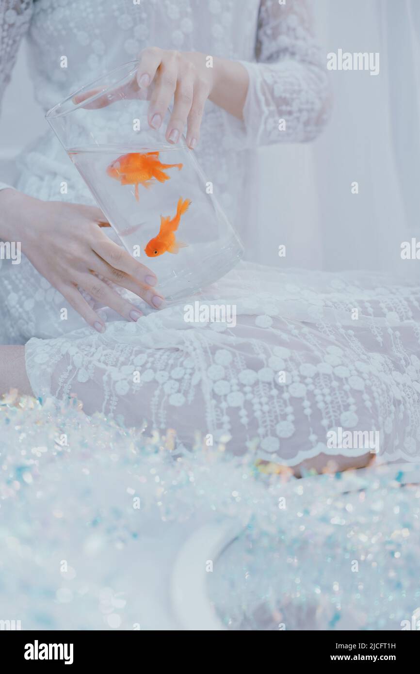 Girl with goldfish in white Stock Photo - Alamy