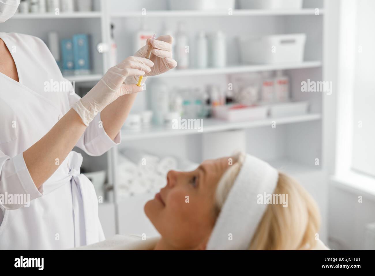 Professional doctor is preparing a syringe for injection in beauty ...