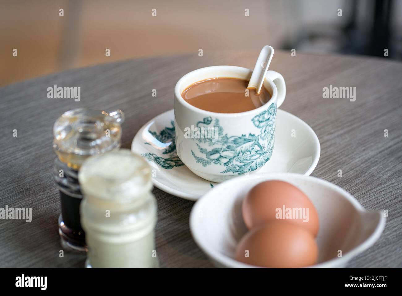 Coffee with boiled eggs, soy sauce and white pepper on table ...