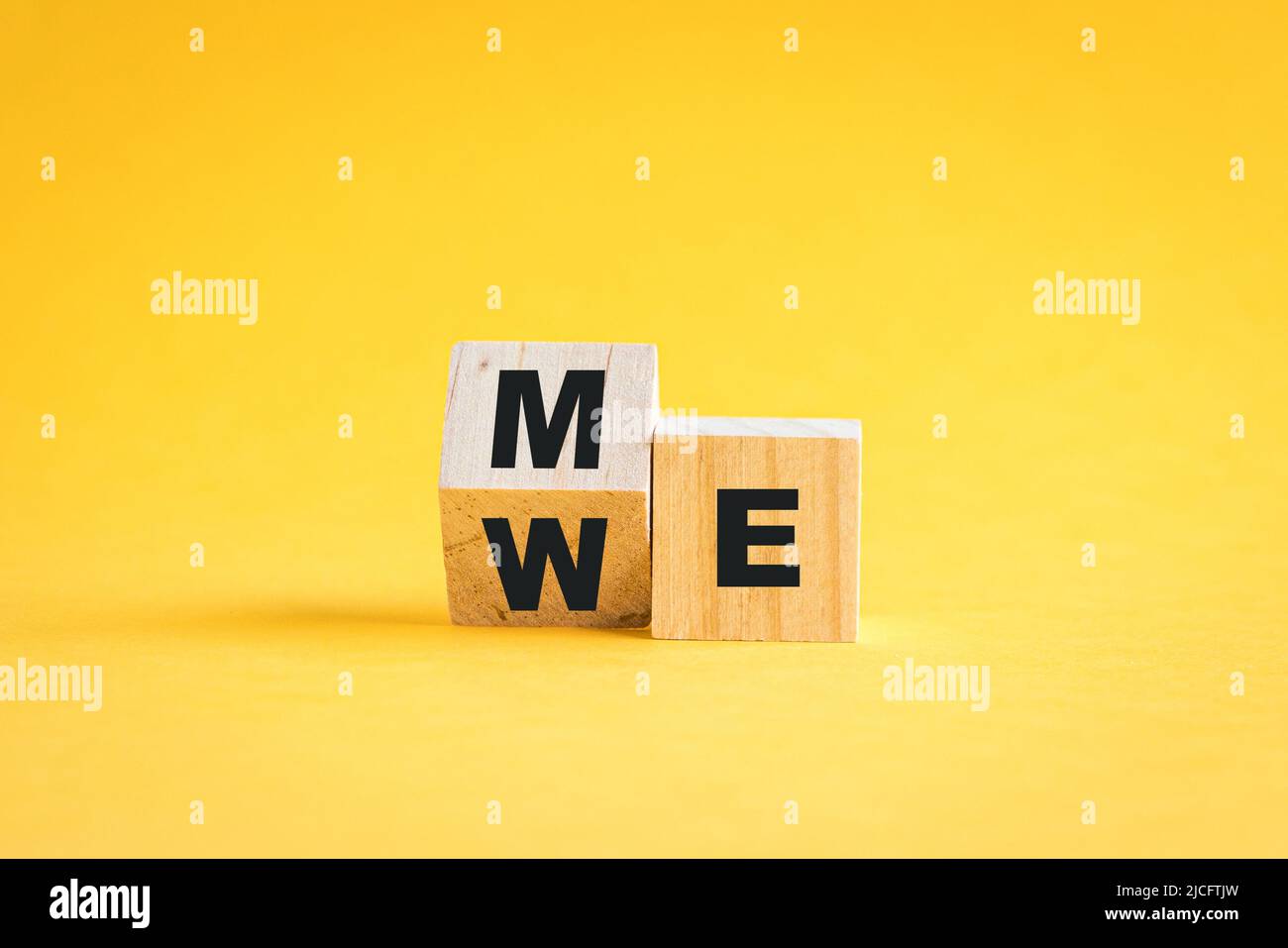 Wooden cube blocks flip from me to we. Teamwork concept. On yellow ...