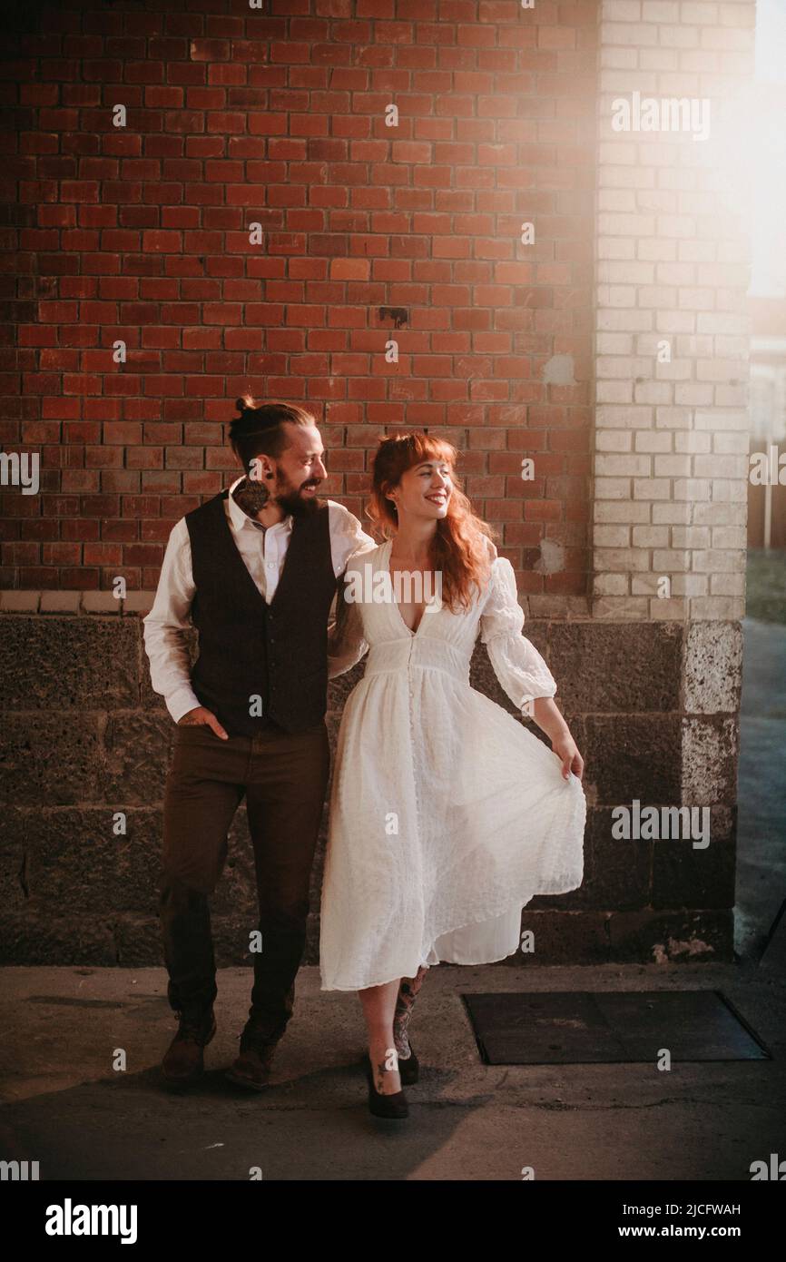 Young couple in love in front of brick wall Stock Photo - Alamy