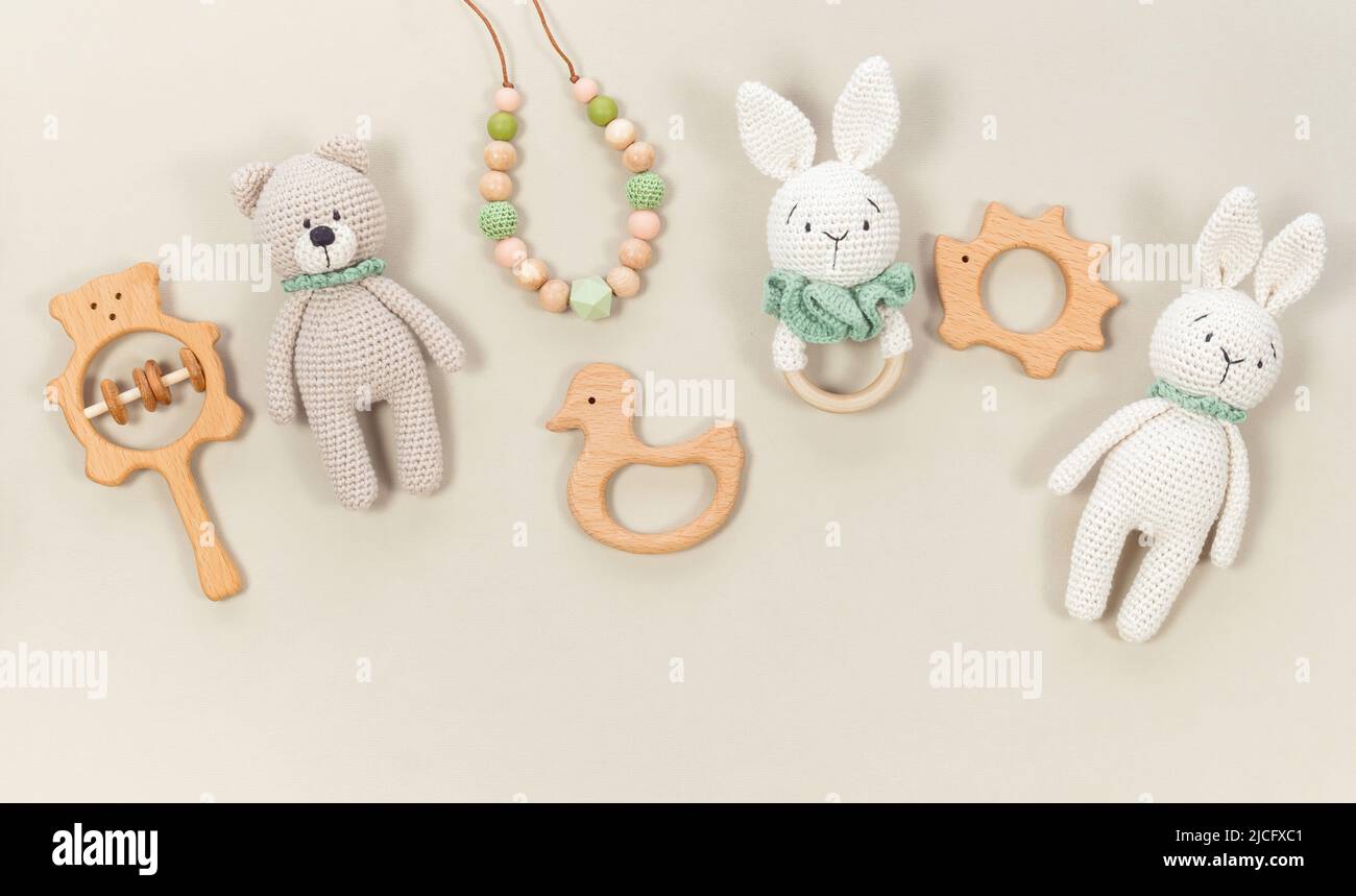 Baby toys background. Knitted bunny, handmade teddy bear and wooden ...