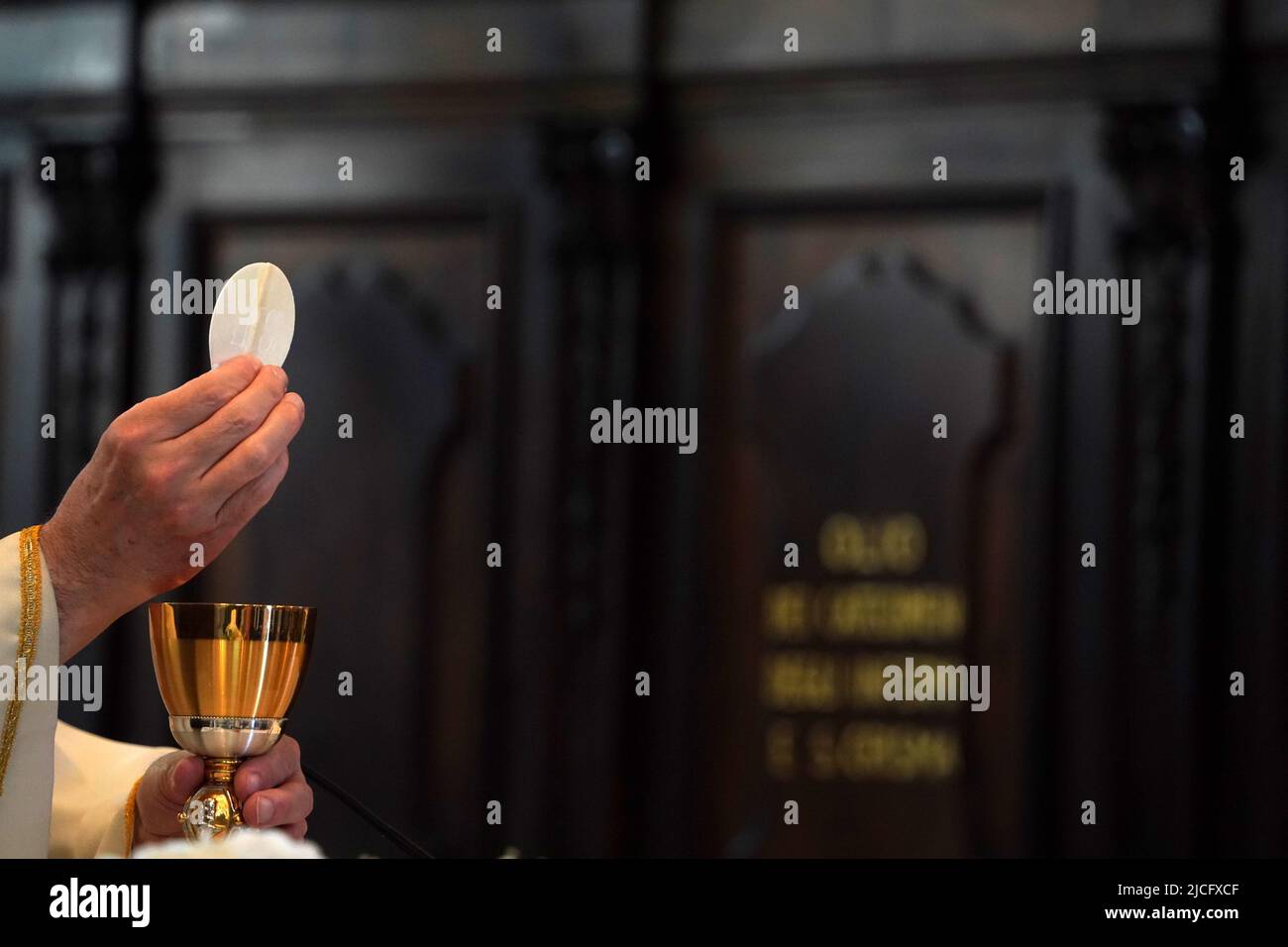 Priest showing the host during the mass detail Stock Photo - Alamy
