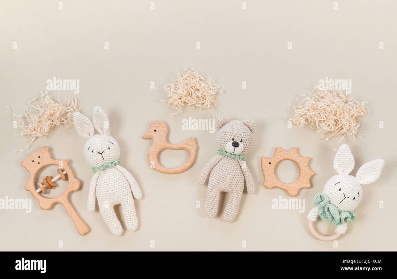 Baby toys on a pastel beige background. Wooden and knitted handmade ...