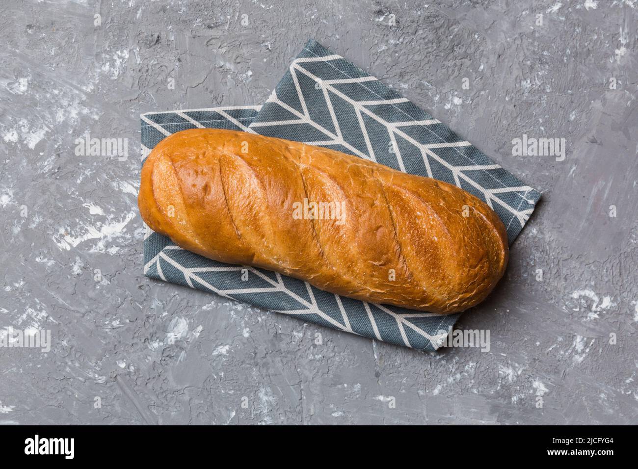 freshly baked bread with napkin on rustic table top view. Healthy white ...