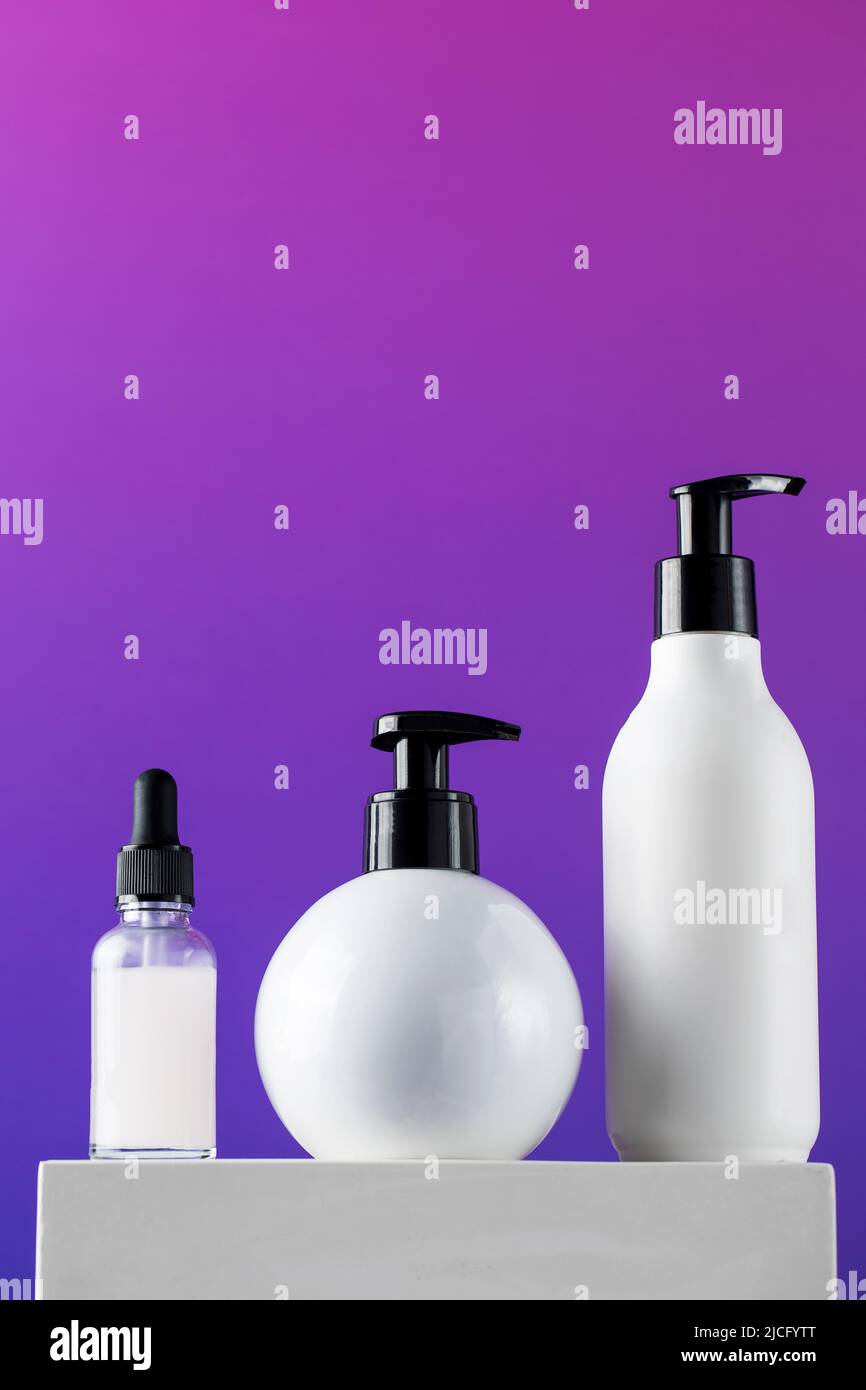 Mockups of white dispensers and droppers with routine cosmetics on a ...