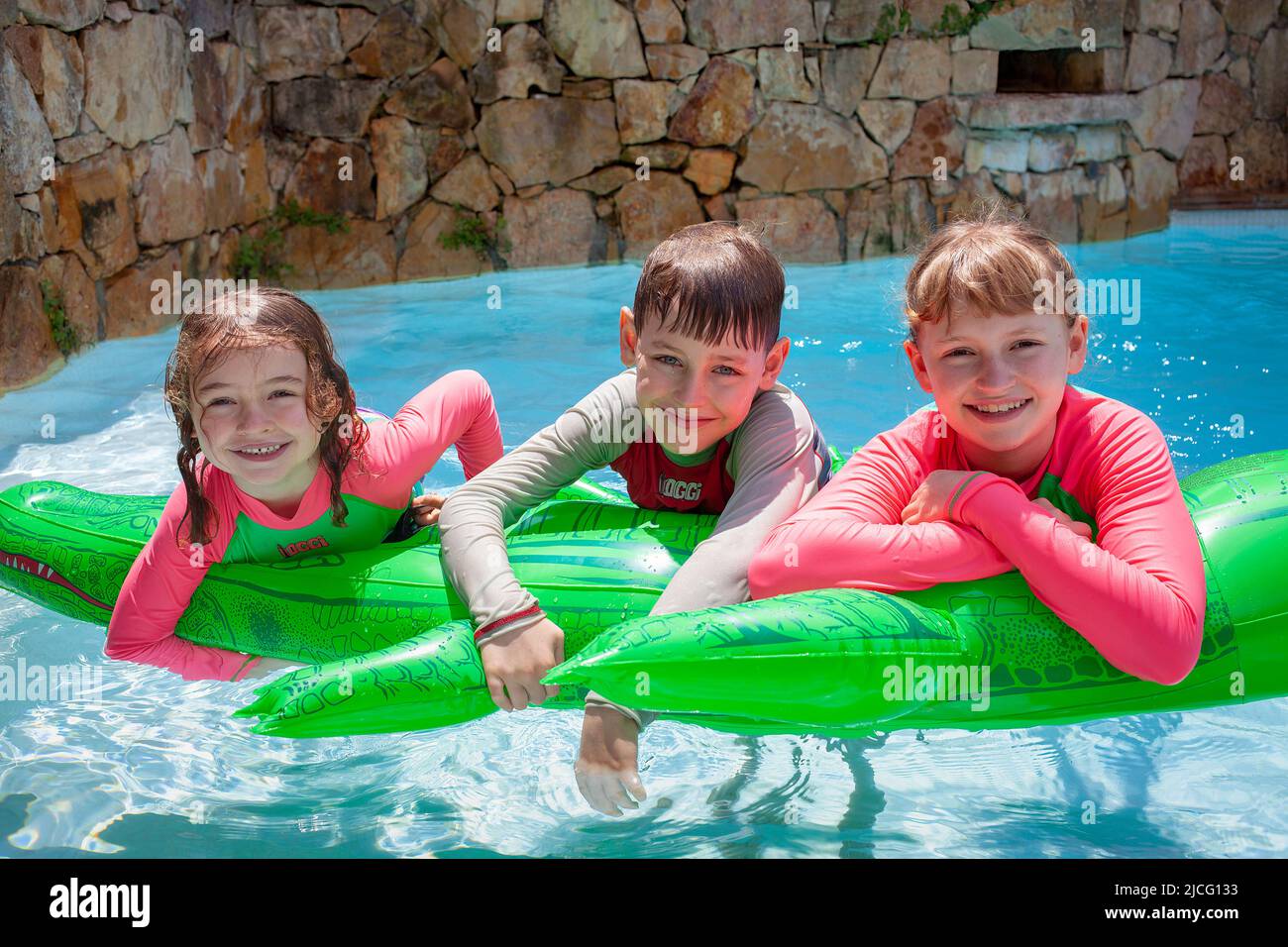 Cooling off in the pool with a large green plastic Lilo shaped like a ...