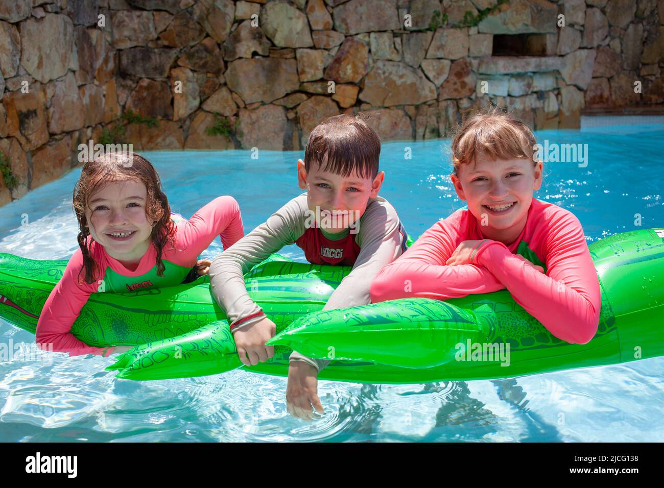 Cooling off in the pool with a large green plastic Lilo shaped like a ...