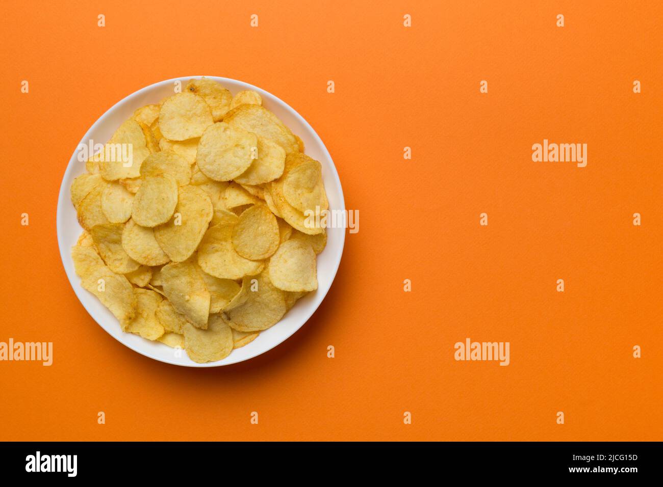 Potato chips on bowl isolated on colored background. Delicious crispy ...