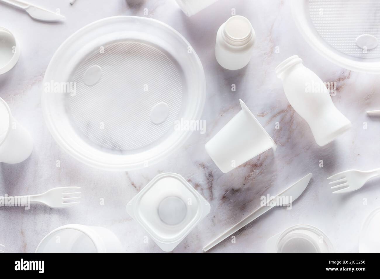 disposable plastic tableware and cutlery close-up. concept of pollution ...