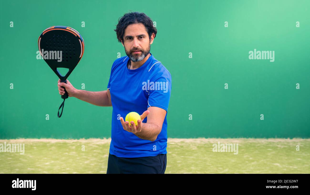 Monitor of padel holding black racket with yellow tennis ball in the ...