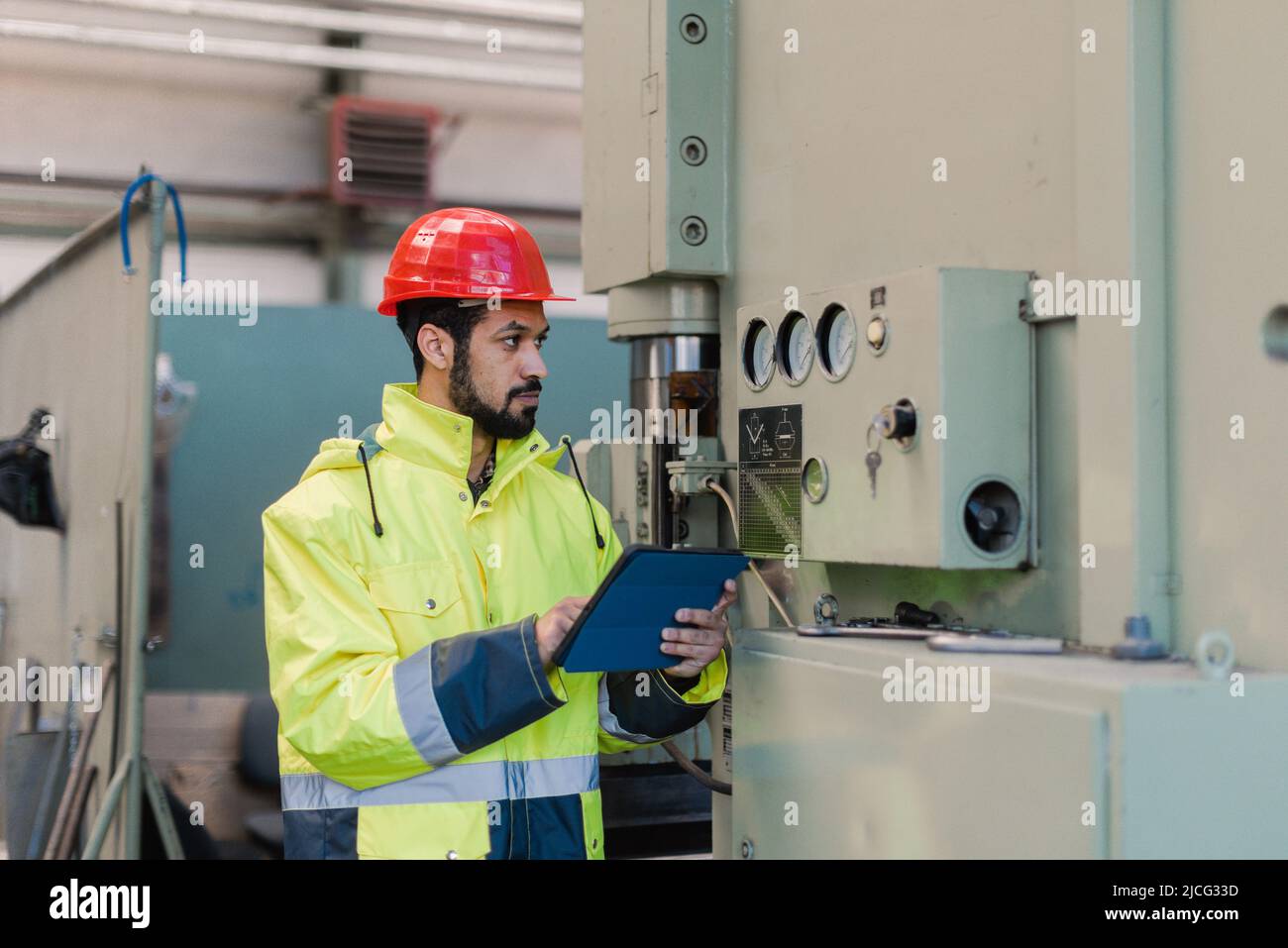 Portrait of engineer male using tablet while checking machines in ...