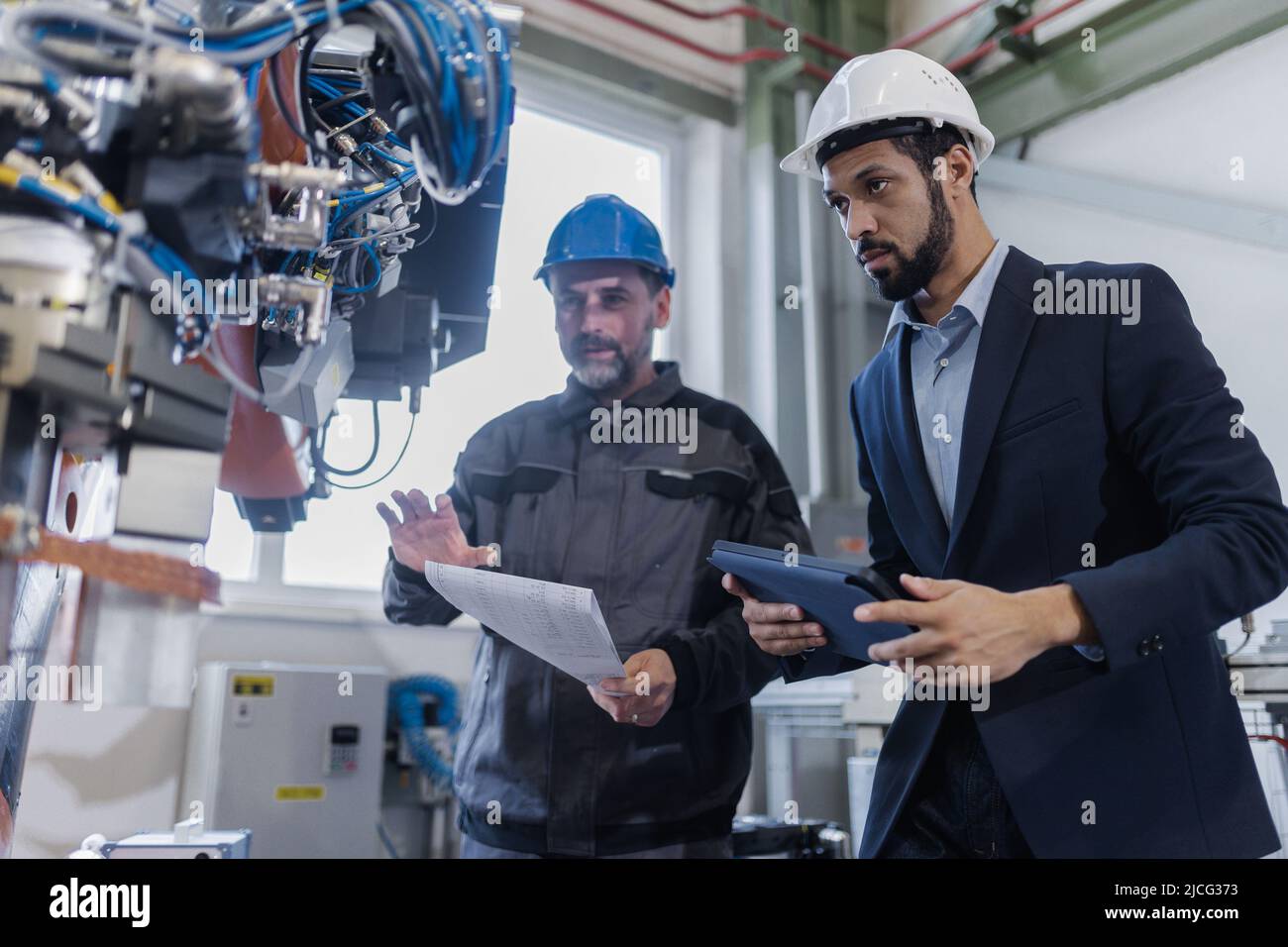 Engineering manager and mechanic worker doing routine check up in ...