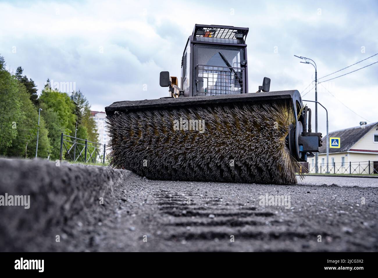 Cleaning of garbage from the road. a rotating mechanical machine brush ...