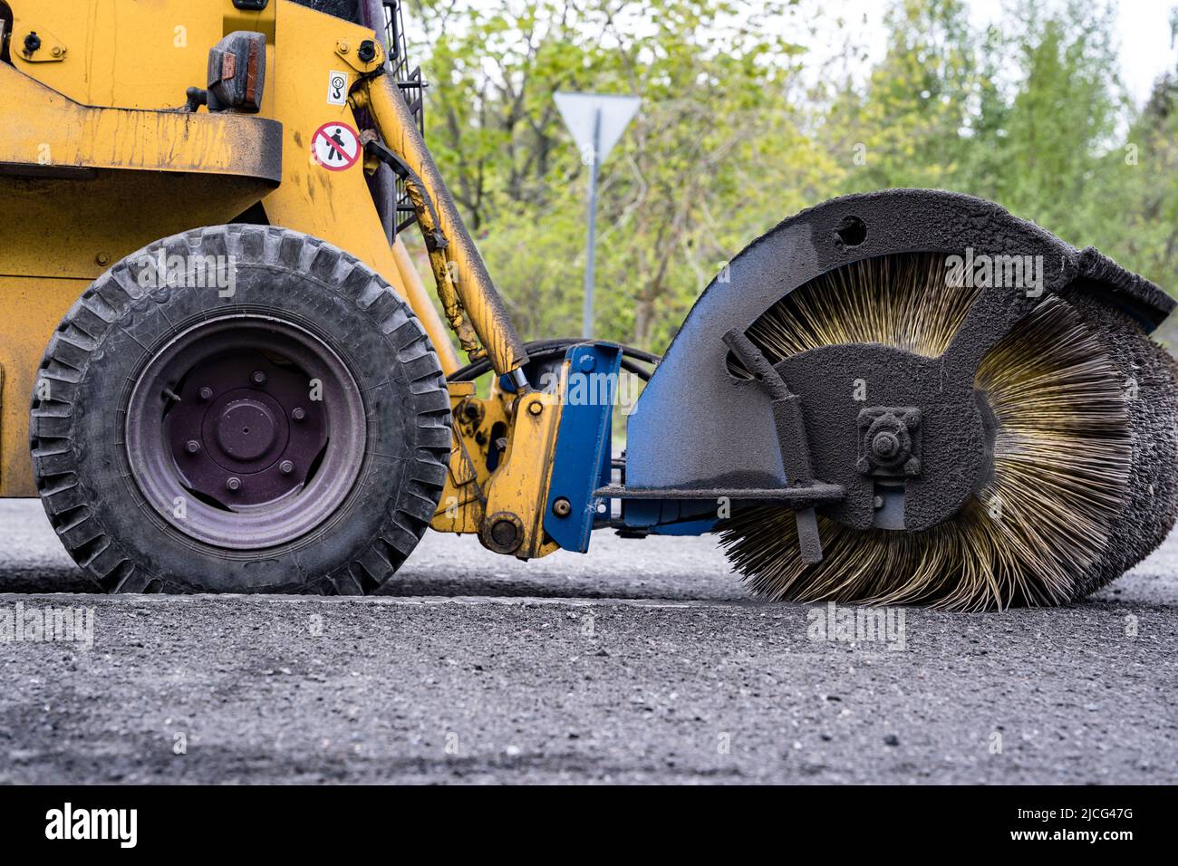 Cleaning of garbage from the road. a rotating mechanical machine brush ...