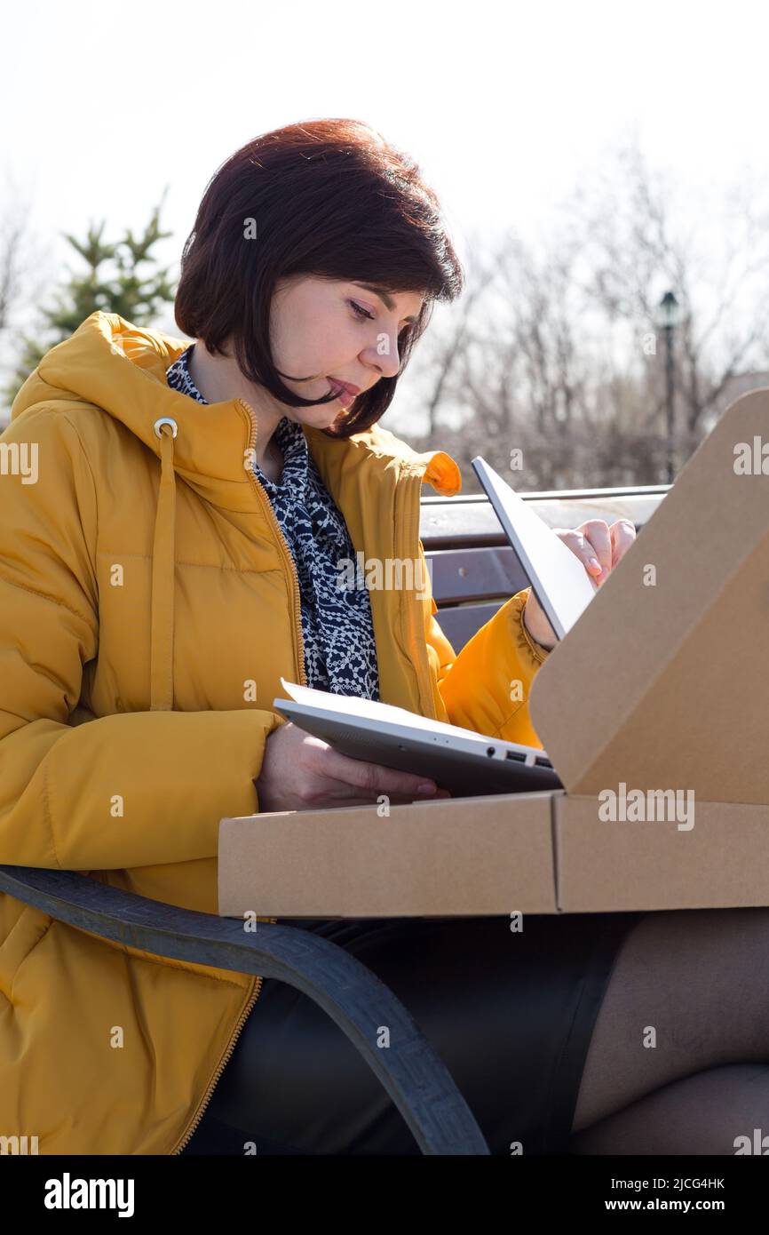 Freelancer woman opening a box with a new laptop on the street Stock ...