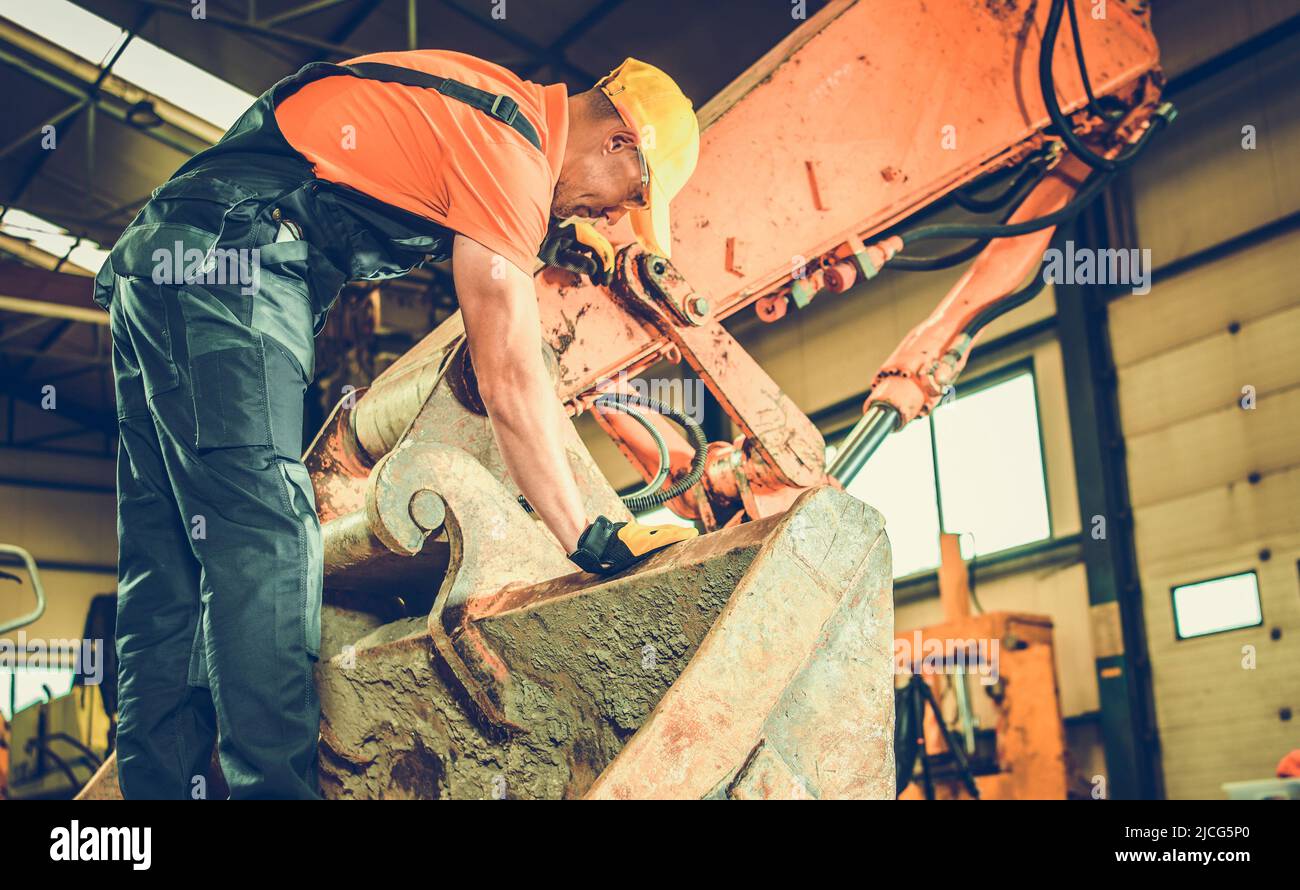 Heavy Duty Excavator Mechanic Taking Closer Look Into the Crawler Iron ... Heavy Duty Excavator Mechanic Taking Closer Look Into the Crawler Iron ...