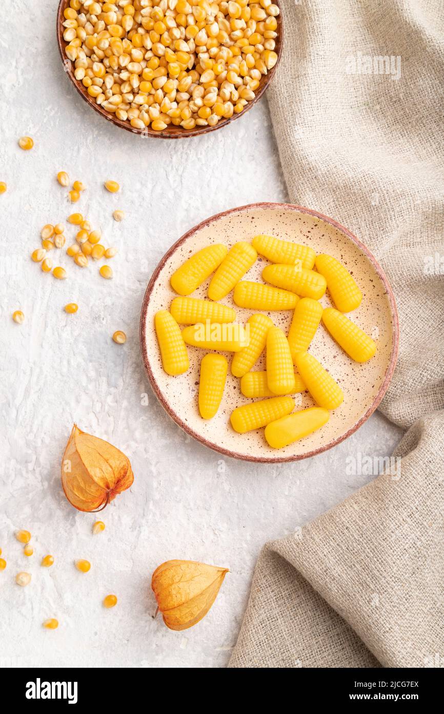 Jelly corn candies on gray concrete background and linen textile. top view, flat lay, close up ...