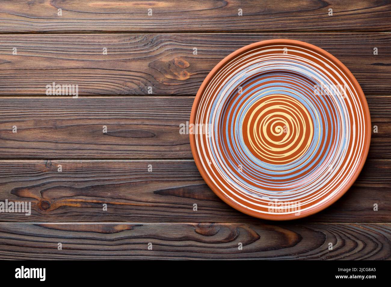 Top view of empty colorful plate on wooden background. Empty space for ...