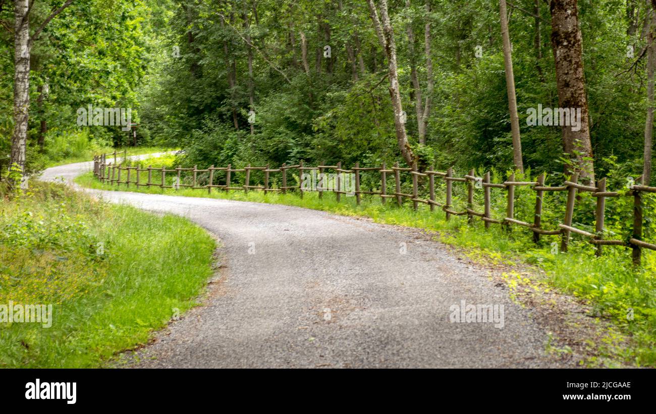 landscape with a simple country road and a wooden fence along the edge ...