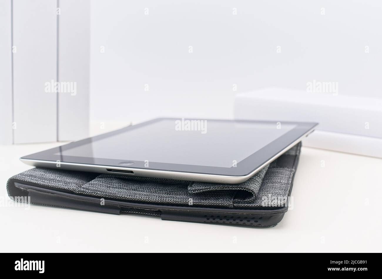 Apple ipad first generation , case on a bright desk with books against ...