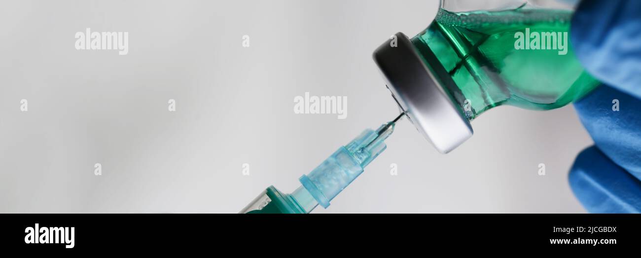 Medical worker gather liquid from glass bottle in syringe Stock Photo ...