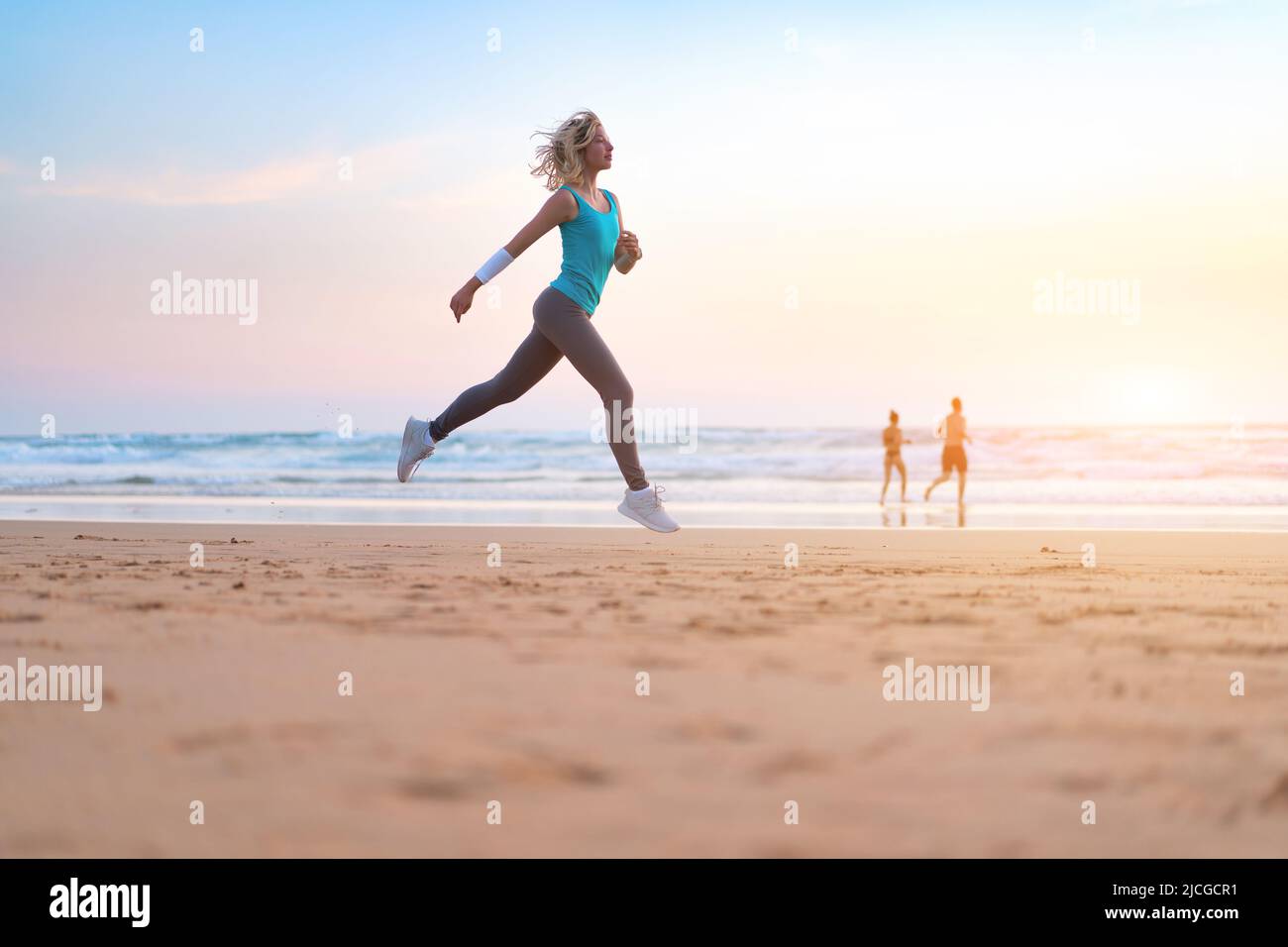 Active sporty woman run along ocean surf by water pool to keep fit and ...