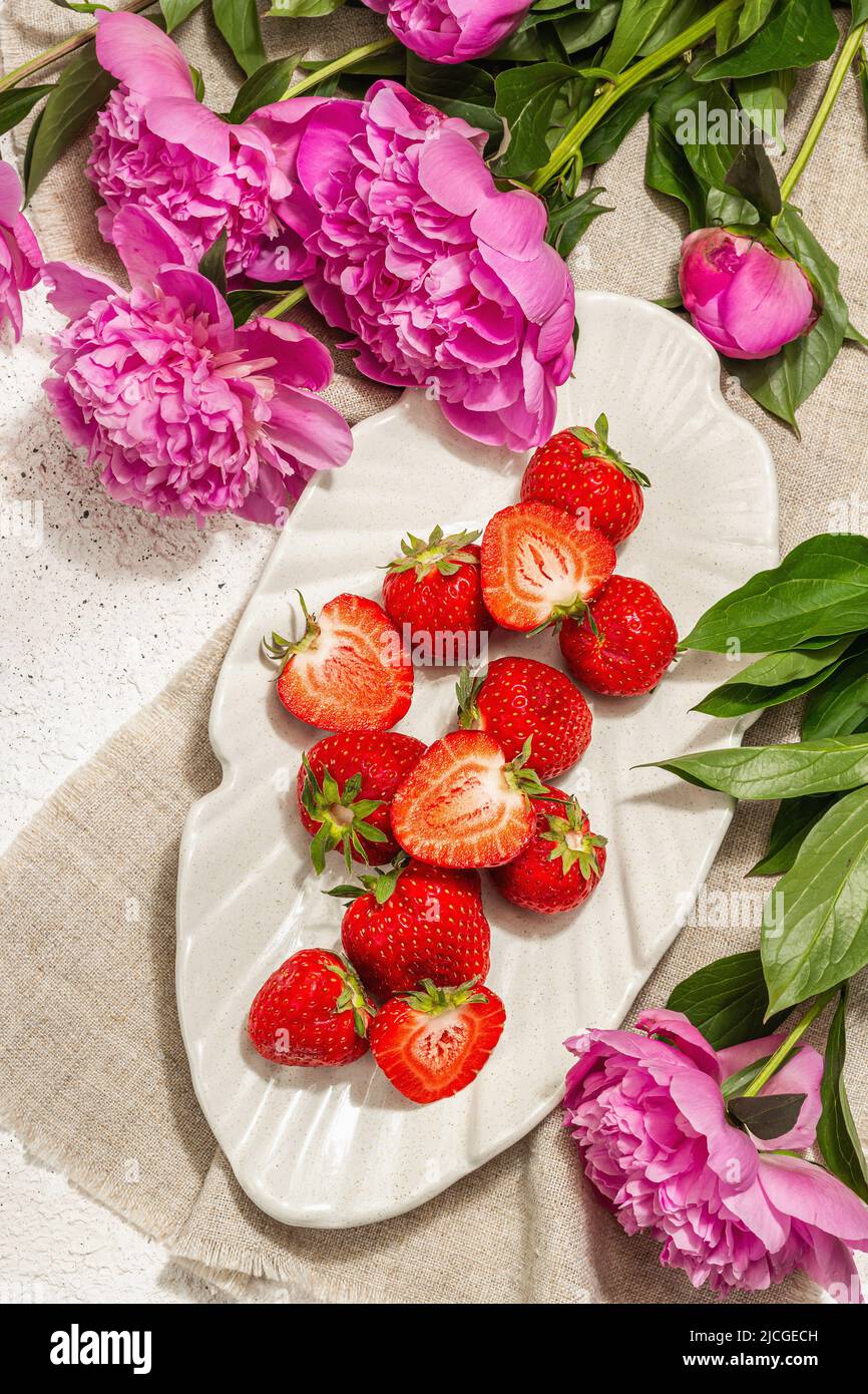 Sweet ripe strawberries and fragrant peonies bouquet. Summer plaster ...