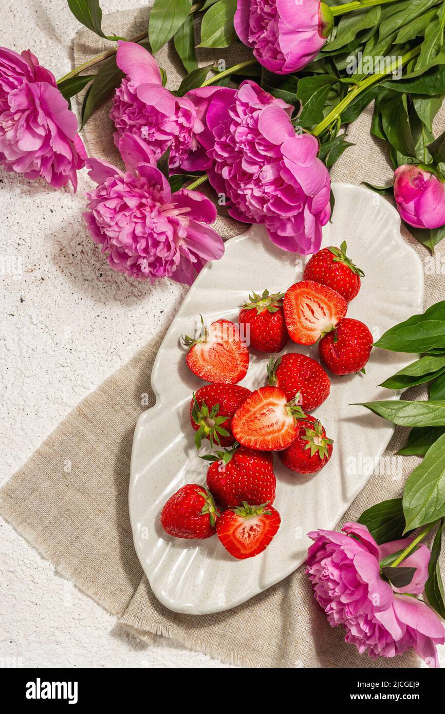 Sweet ripe strawberries and fragrant peonies bouquet. Summer plaster ...