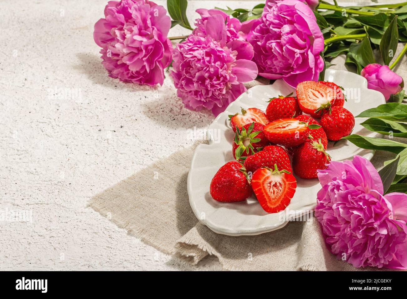 Sweet ripe strawberries and fragrant peonies bouquet. Summer plaster ...