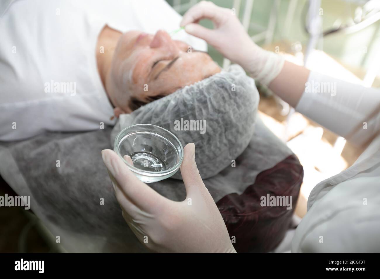 Close-up doctor cosmetologist applies a treatment solution for skin ...