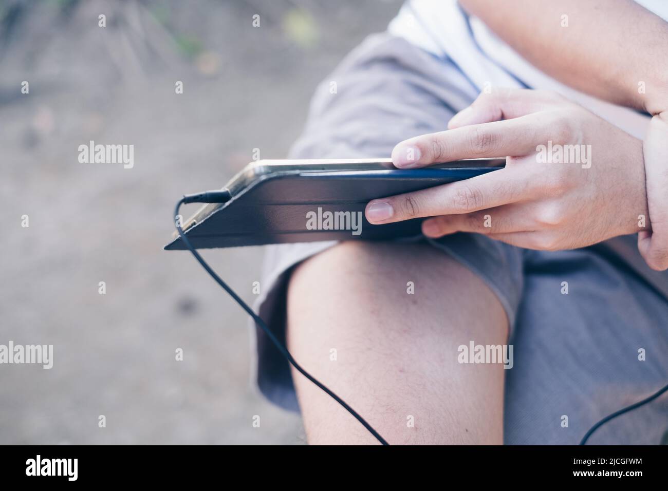 Young boy's left hand holding an electronic tablet. Selective focus ...