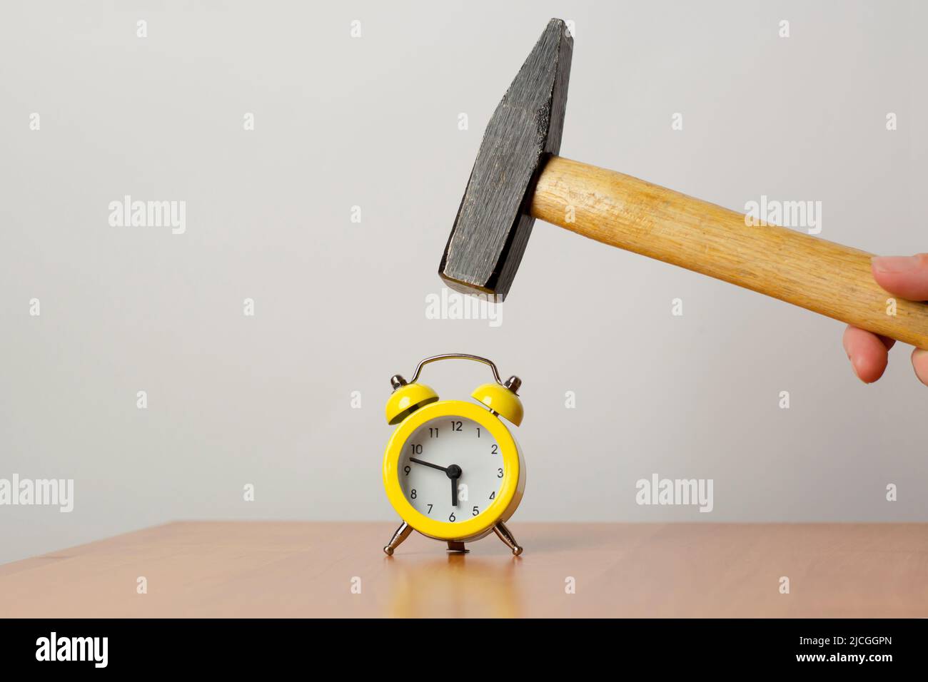 The hammer breaks the alarm clock. Tap the hammer on the alarm clock ...