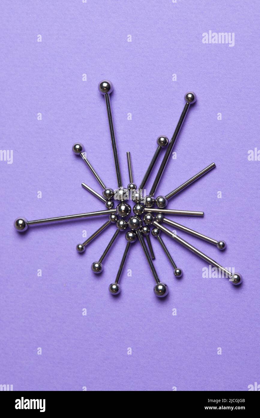 Piercing earrings close-up. On a Violet background Stock Photo - Alamy