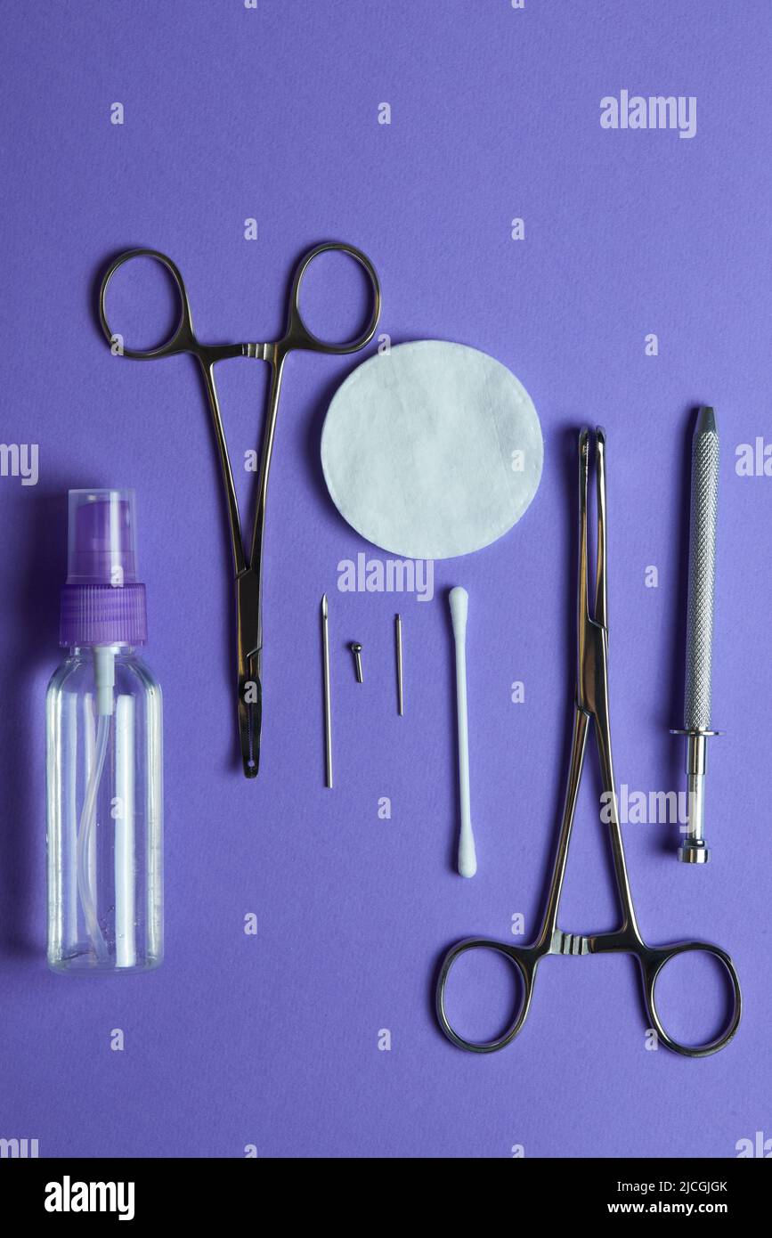Piercing earrings close-up. On a Violet background Stock Photo - Alamy