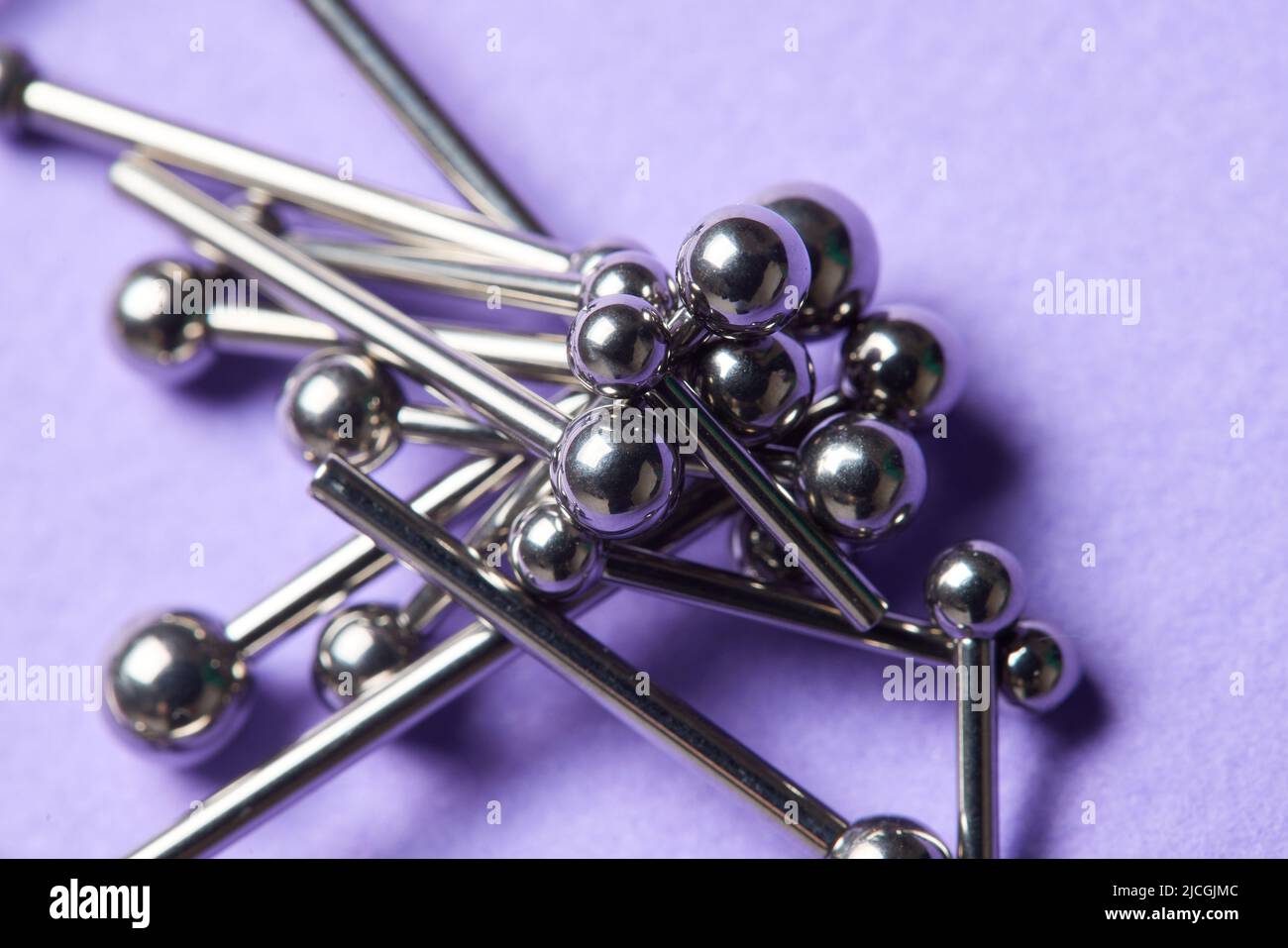 Piercing earrings close-up. On a Violet background Stock Photo - Alamy