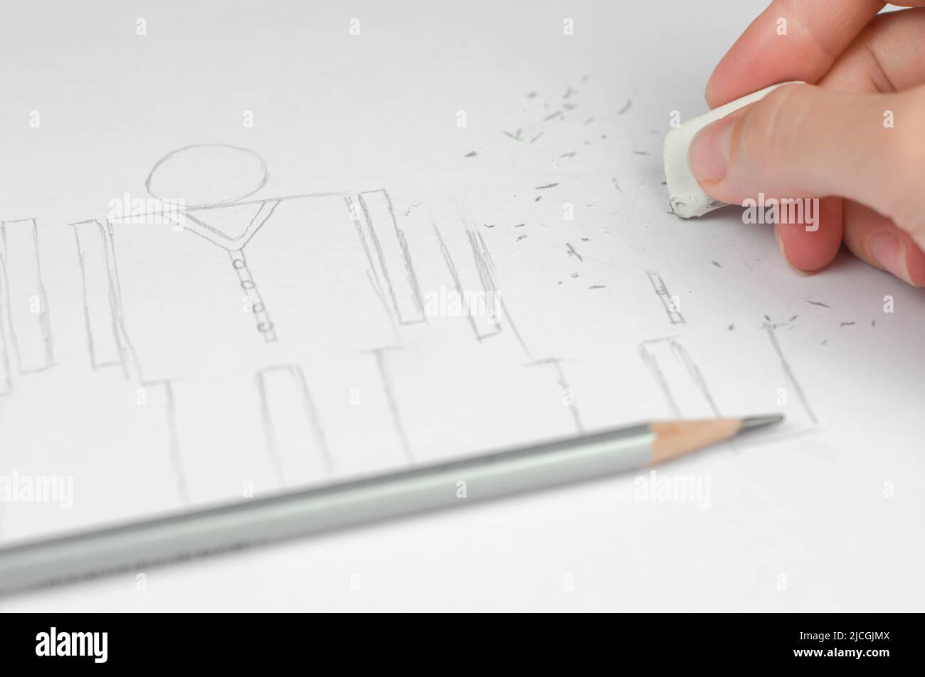 Women's hands wipe a person drawn with a pencil with an eraser. The ...