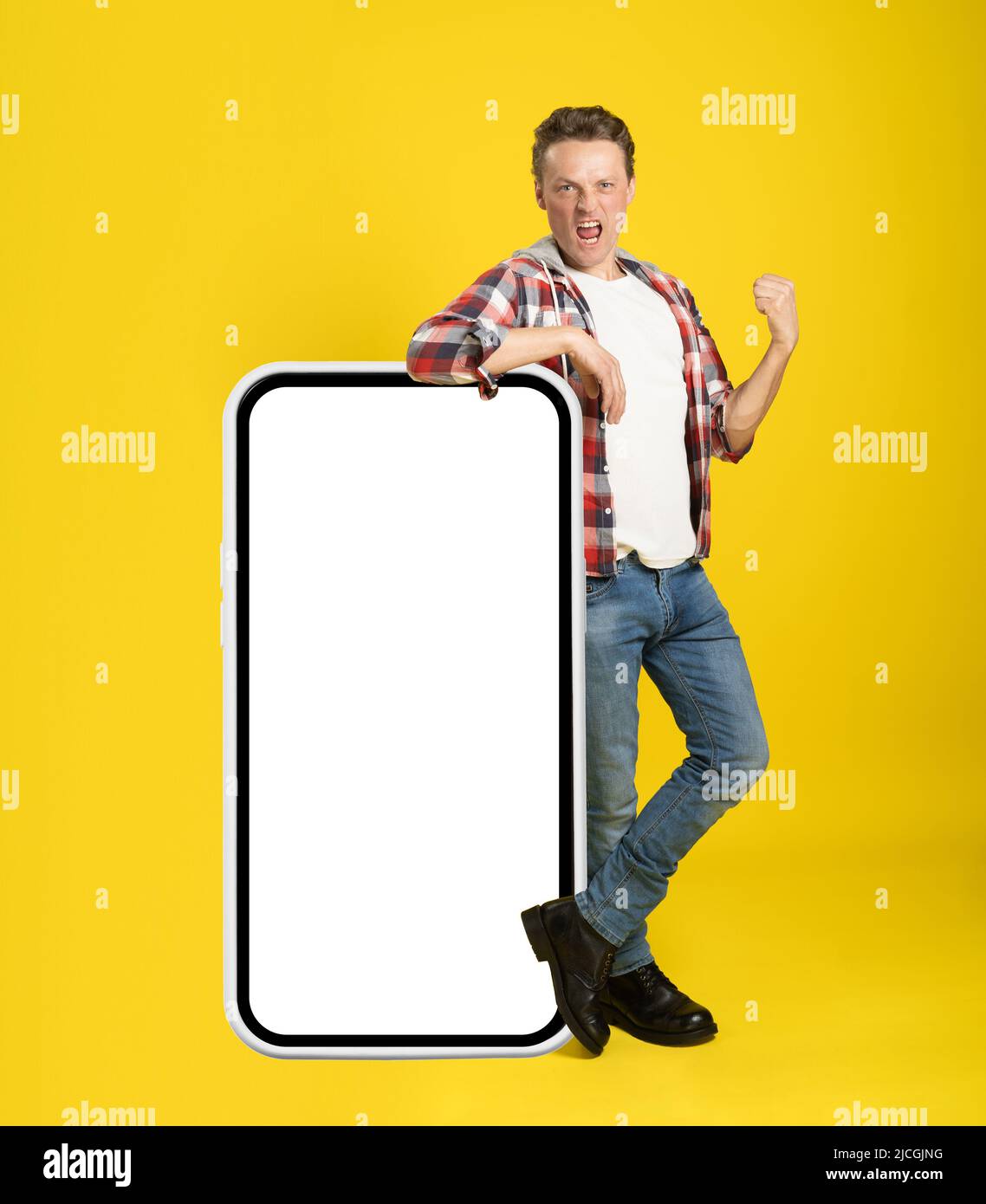 Pointing on huge, giant smartphone with white screen young man leaned ...